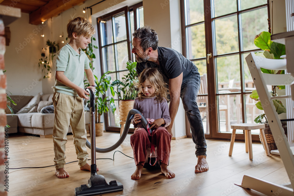 Father and kids cleaning house, vacuuming the floors with a vacuum ...