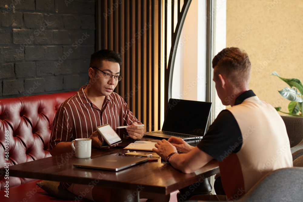 Trader explaining client how to read stock market charts when learning ...