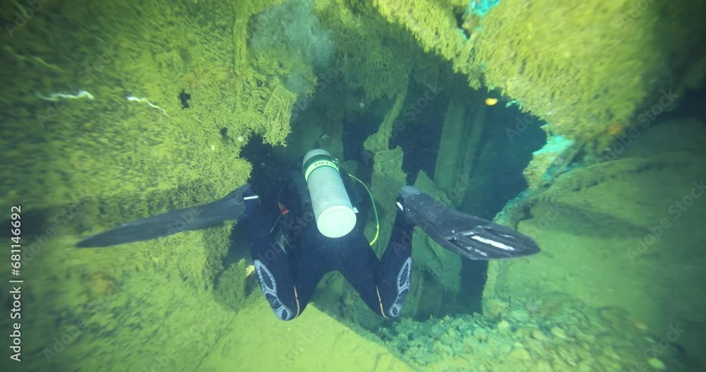 Scuba Diver Exploring Inside Big Ship Wreck in darkness. The ship was ...