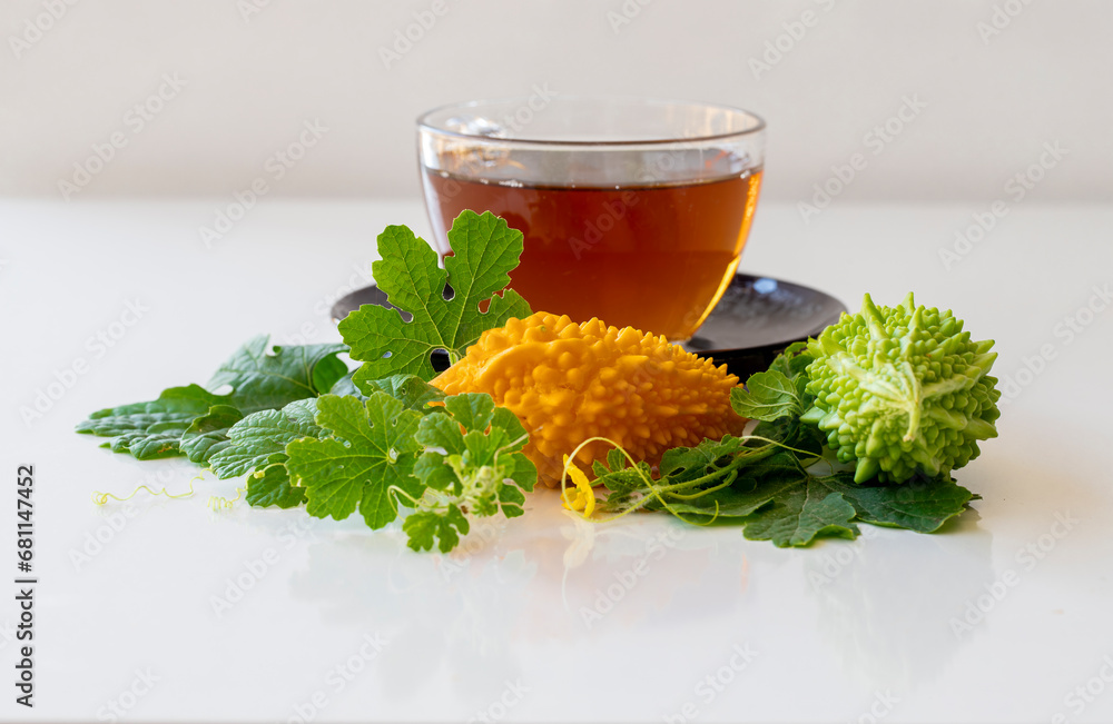 Bitter gourd or bitter melon tea in transparent cup and fresh bitter ...