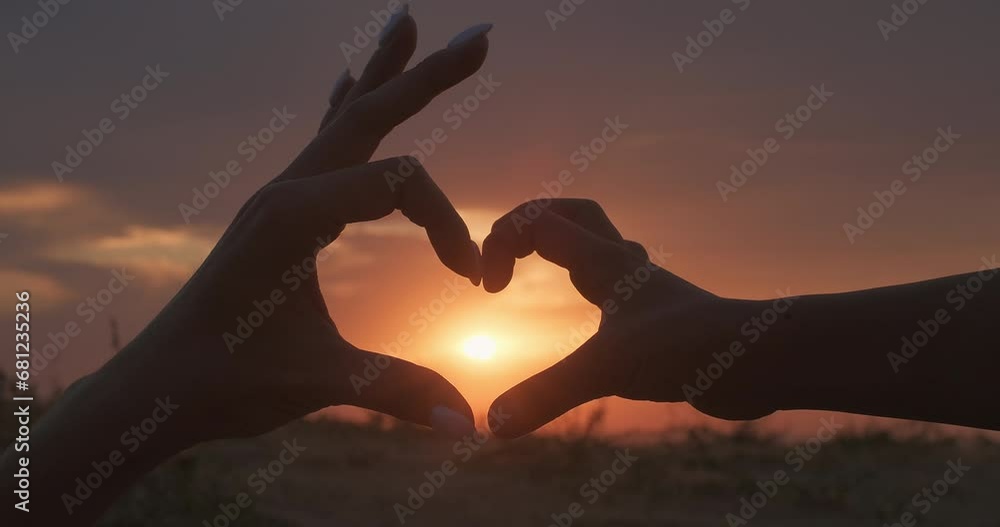 Two hands coming together to form a heart shape with their fingers at ...