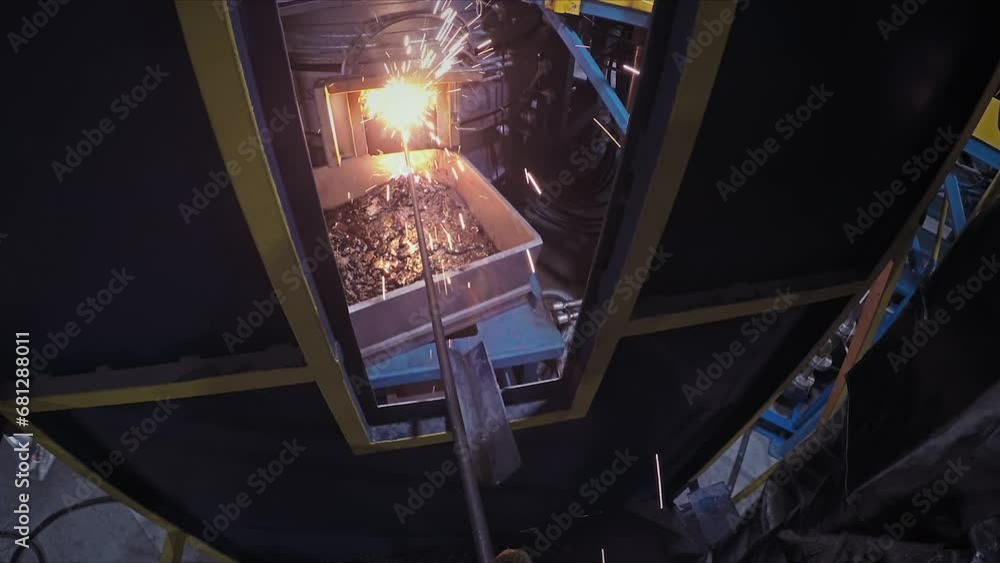 Metal cast process, steel scrap is melting in the foundry. Automated ...