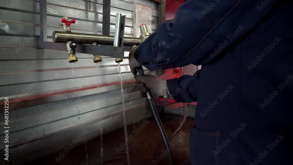 Manufacturing Plant. A Laborer is testing the Pipe that is Leaking ...