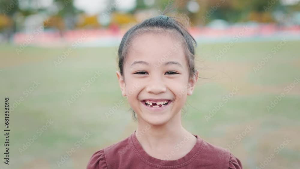 Lush greenery of a playground, close up Asian adorable 7-year-face with ...