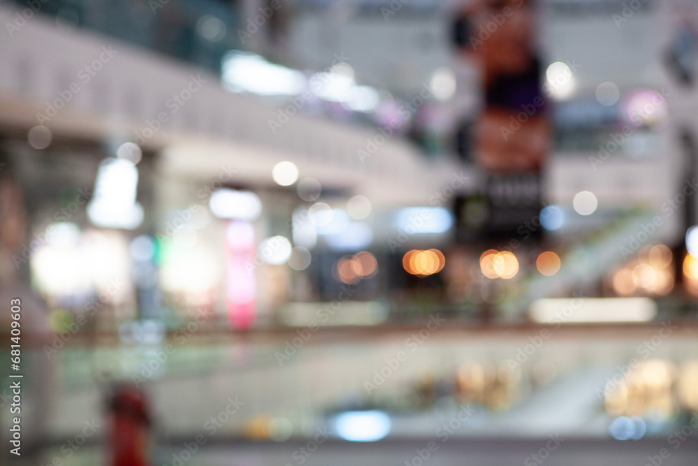 Blurry view of a bustling mall interior with various shops and ...