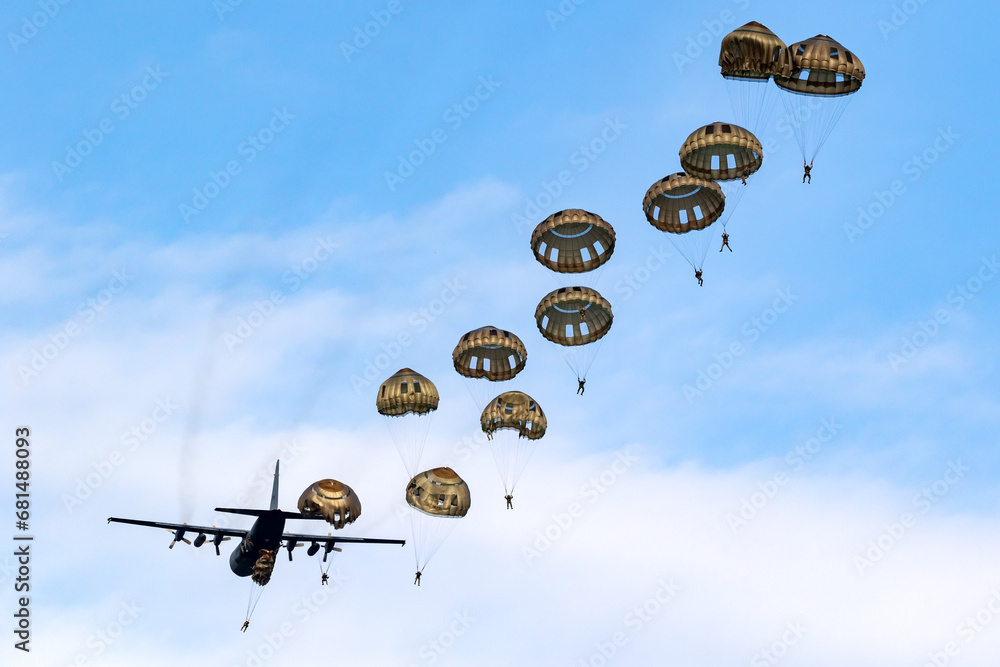 Military parachutist paratroopers parachute jumping out of an air force ...