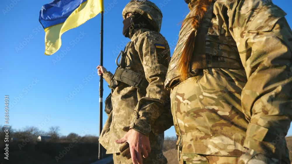 Young soldiers of ukrainian army standing at peak of hill with raised ...