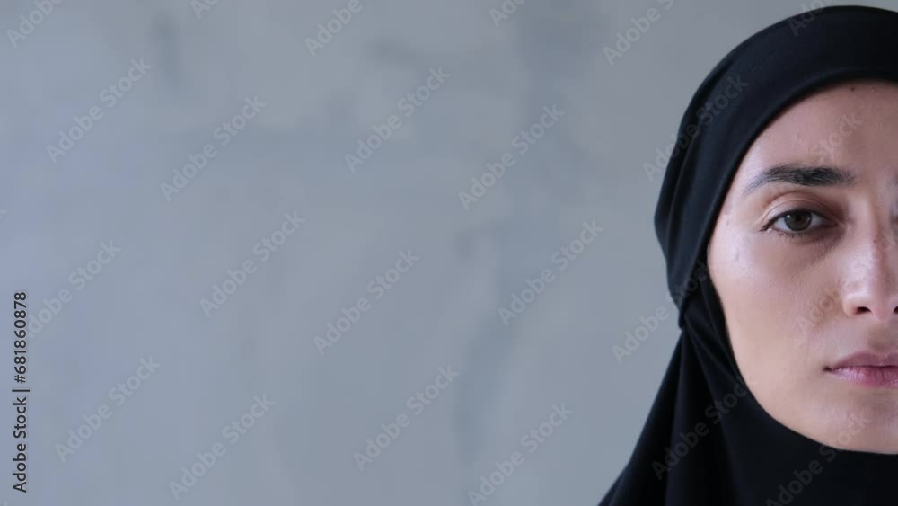 Muslim woman looks mysteriously and tensely at, half of full face. Half ...