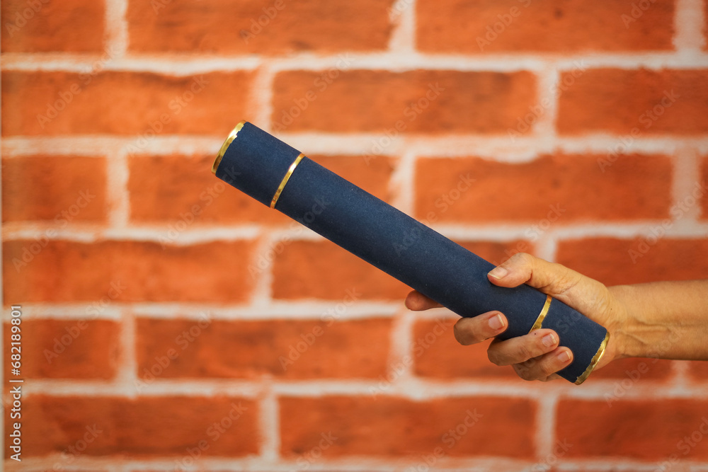 A dark blue diploma cover with golden details being handed over. Image ...