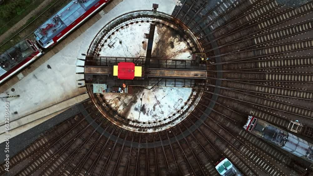 Yellow and red locomotive leaving the railway turntable in the depot ...