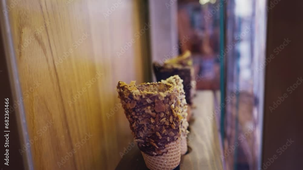 Sweet cones at the gelato ice cream shop showcase window with various ...