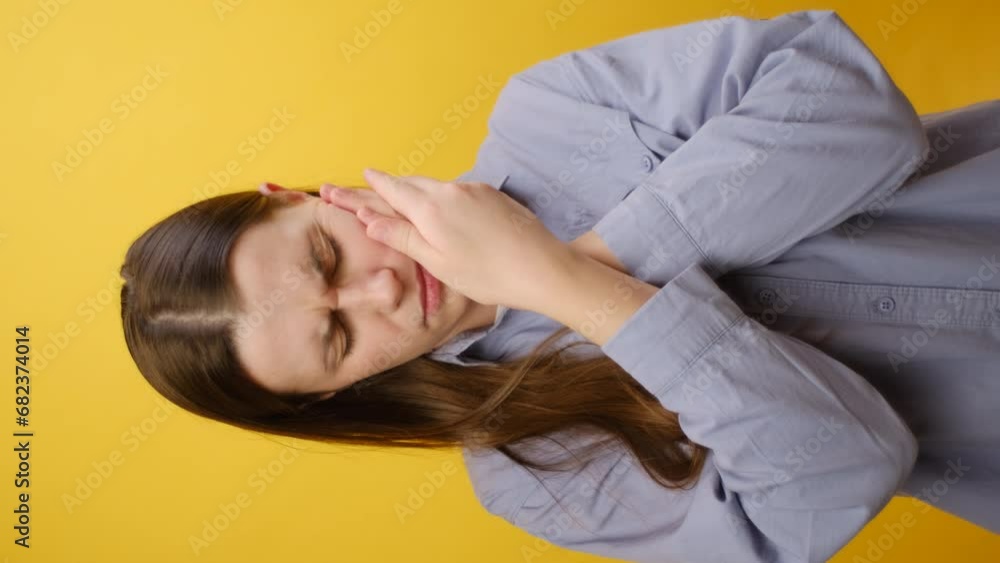 Vertical shot of young woman suffering from toothache, isolated on ...