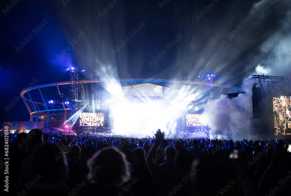 Bright neon stage lights show and smoke effects at a concert. Audience ...