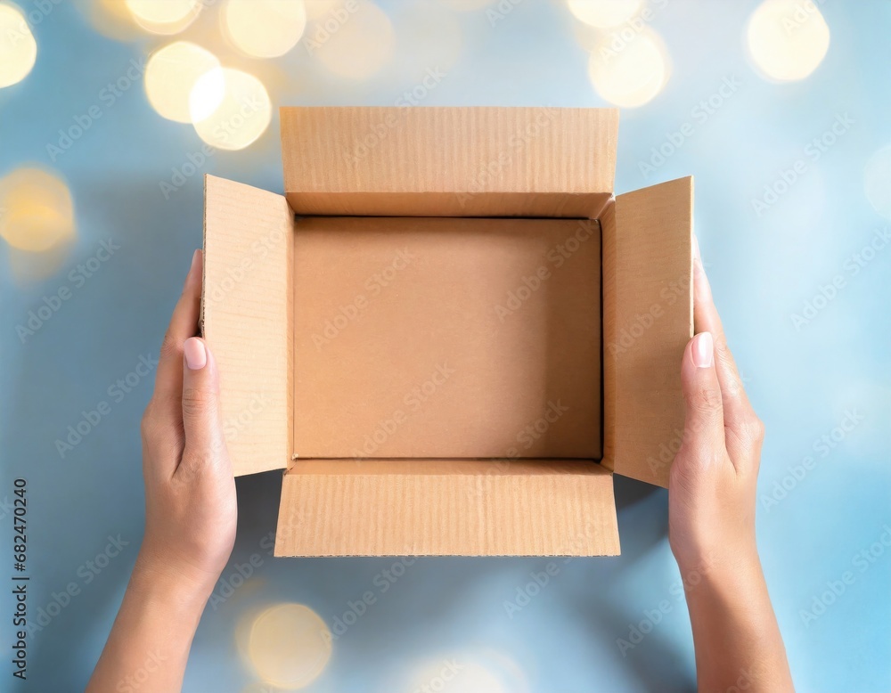 Overview of female hands open an empty brown cardboard box on a light ...