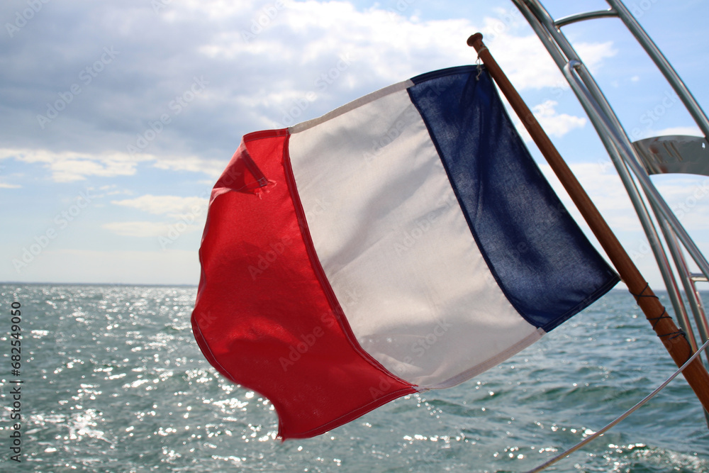 drapeau Français qui flotte au vent à l'arrière d'un bateau en pleine ...