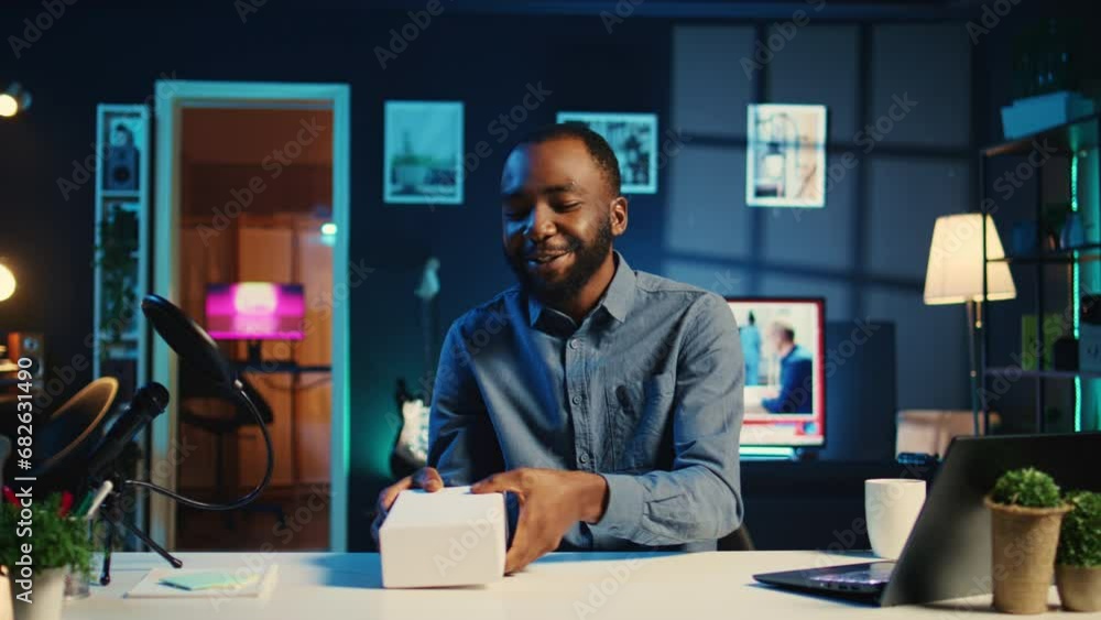 Tech content creator filming packaged product unboxing in neon lights ...