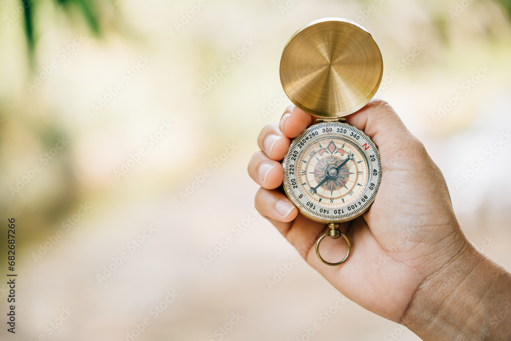 Exploring the forest a woman holds a compass in her hand during a close ...