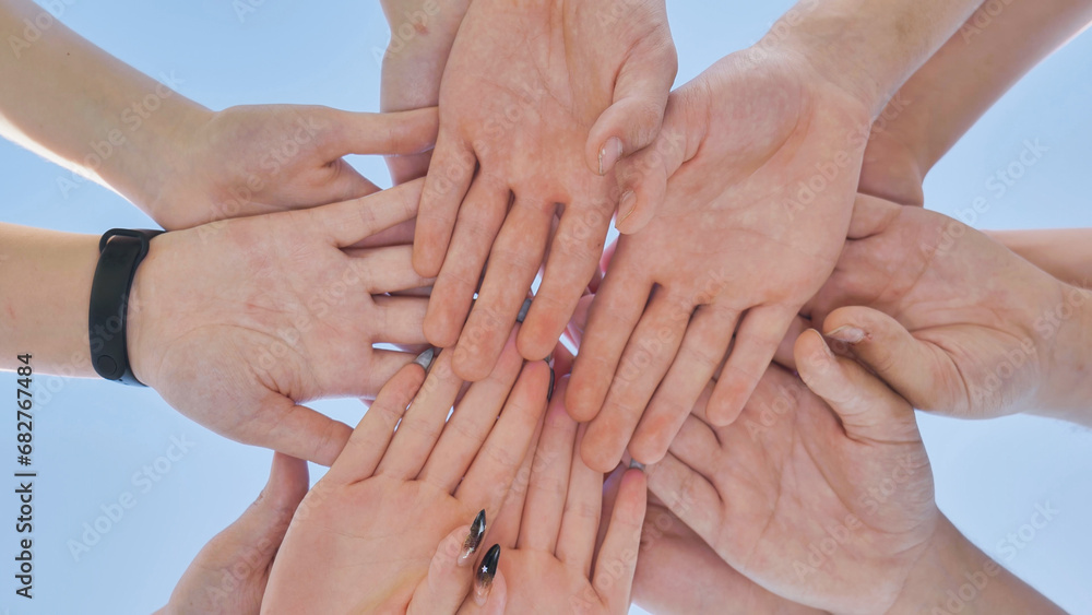 Friends putting their hands together in a sign of unity and teamwork ...