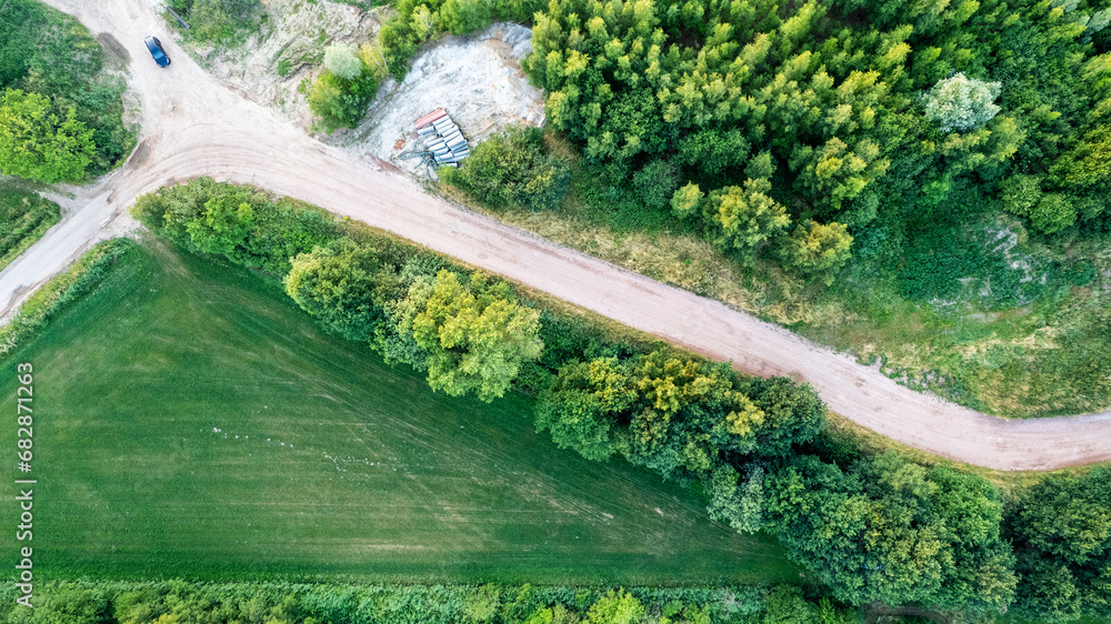 An aerial snapshot reveals a rural crossroads amidst a lush landscape ...