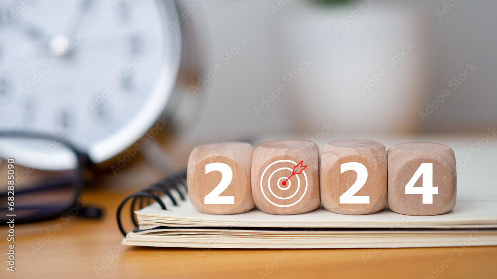 Wooden blocks with letters 2024 with calendar and alarm clock on wooden ...