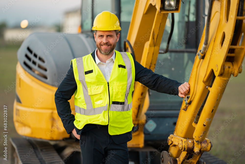 Construction owner near excavator. Confident construction owner in ...