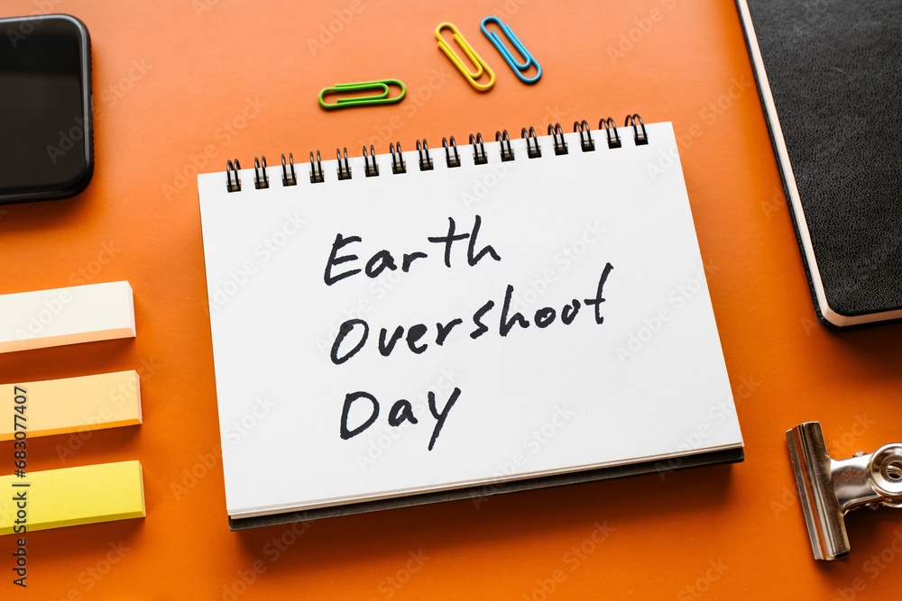 There is notebook with the word Earth Over Shoot Day. It is an ...