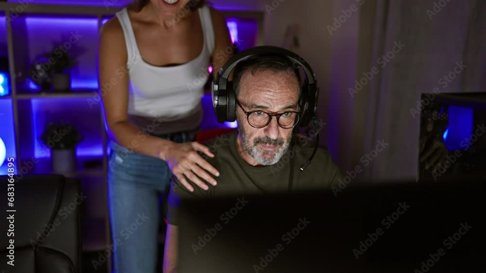 Exciting night in gaming room, two cheerful gamers, father and daughter ...