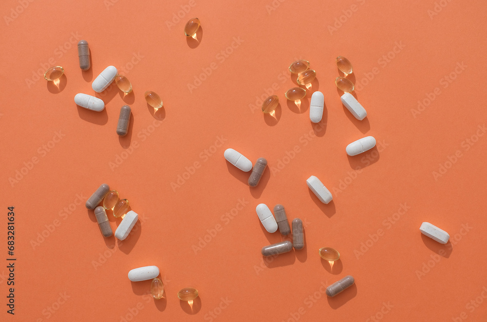 Vitamin E capsules, gray capsules and white tablets are randomly ...