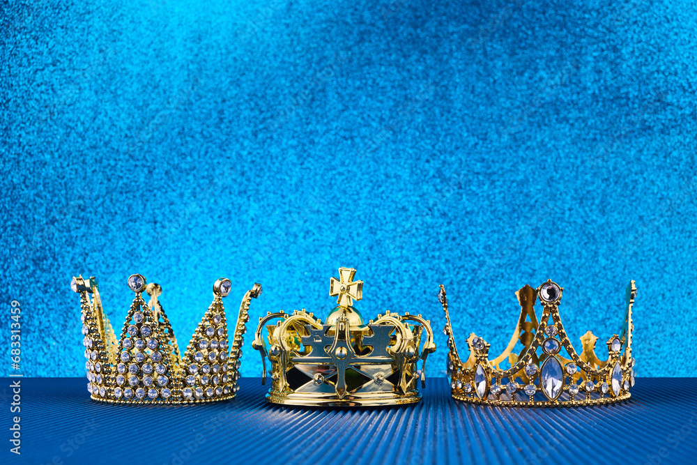 Epiphany Day or Dia de Reyes Magos concept. Three gold crowns on blue ...