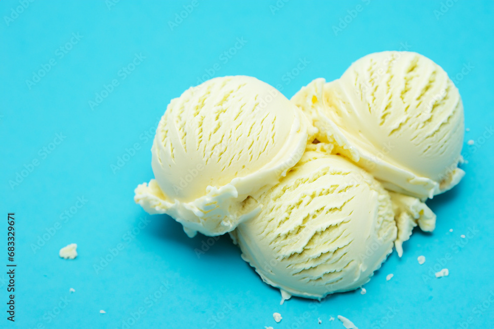 Two scoops of creamy vanilla ice cream sit atop a vibrant blue ...