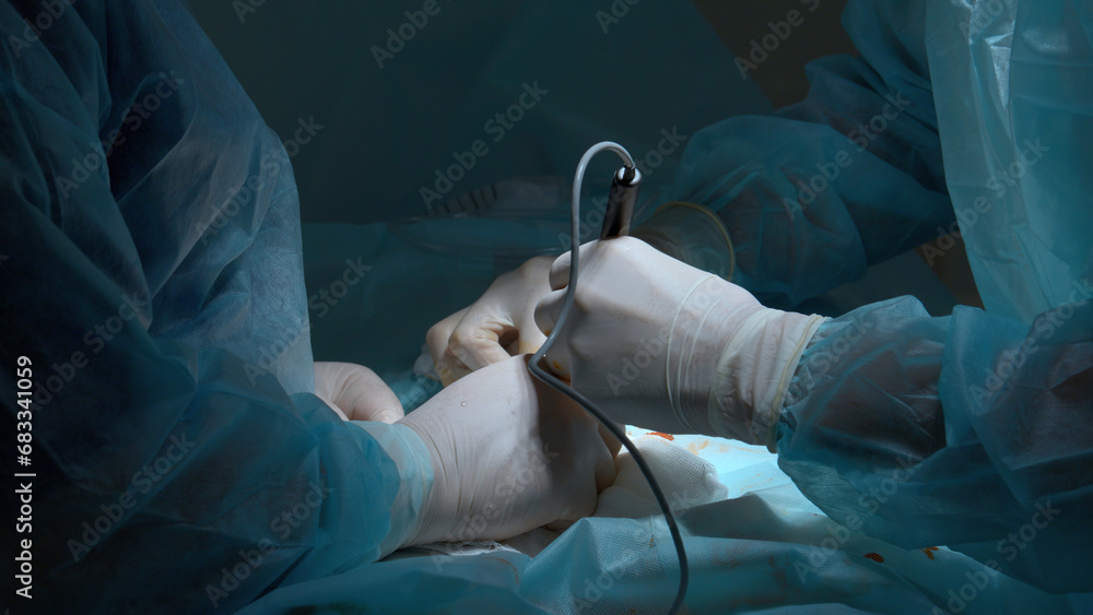 Skilled surgeons in white gloves performing manipulations with patient ...