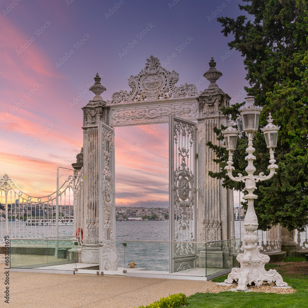 Pair of elaborately decorated white painted metal gates leading to the ...