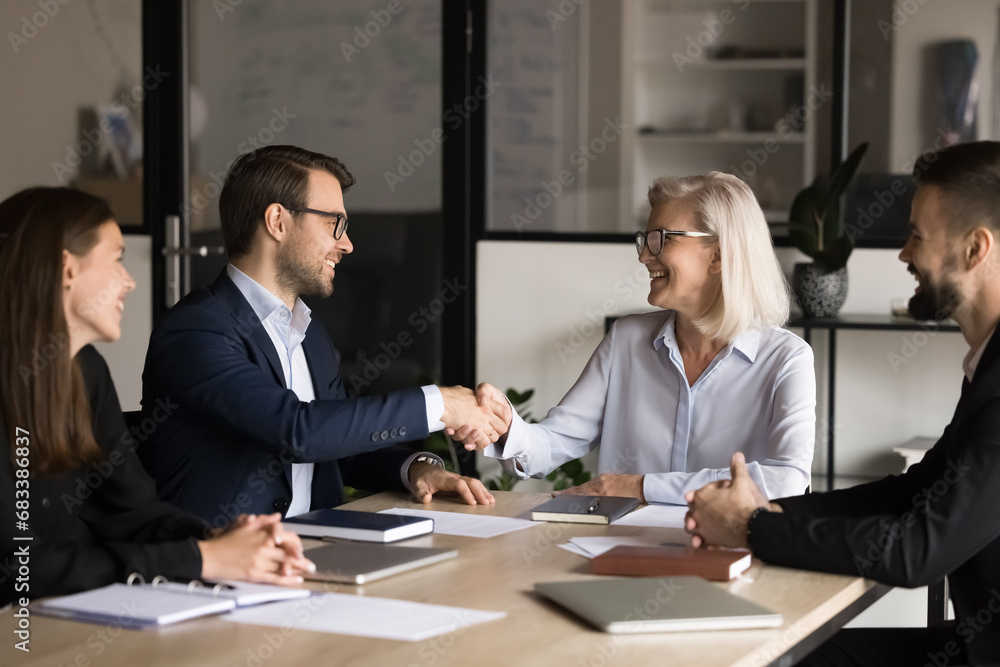 Positive senior business leader woman giving handshake to effective ...