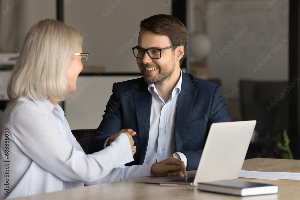 Positive successful professional man in formal suit and glasses shaking ...