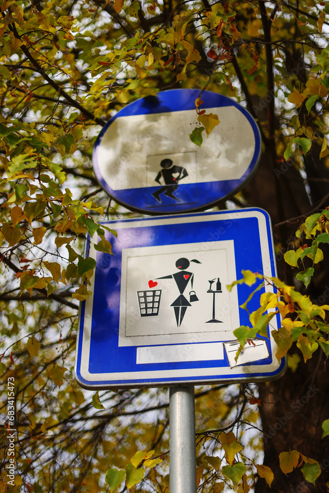 Trash can and road signs near the highway. Stock Photo | Adobe Stock