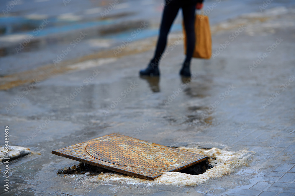 Hole on footpath. Broken manhole, pothole in paving slabs, damaged ...