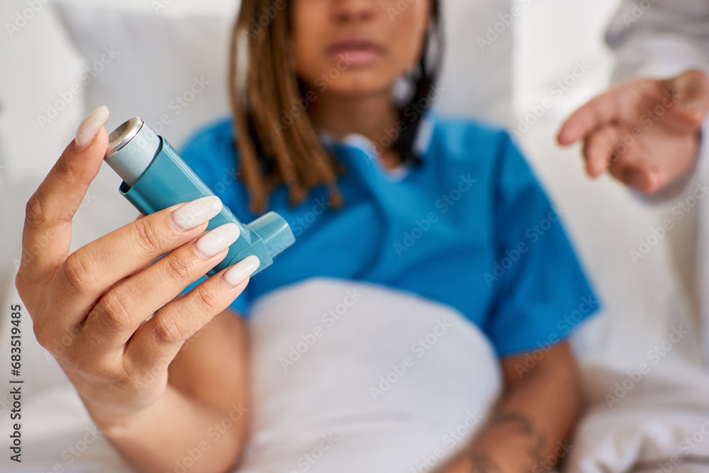 focus on asthma inhaler in hands of african american patient with ...