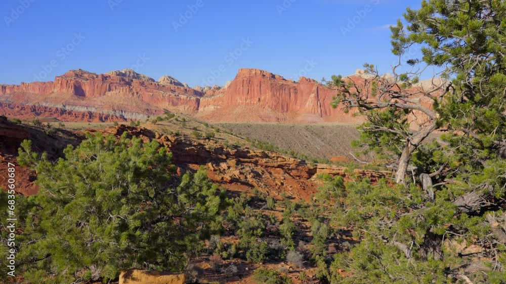 Establishing shot of mountain trail with red rocks background in ...