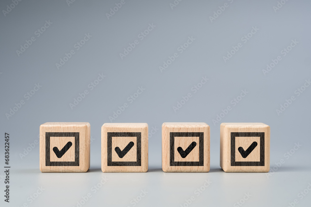 Row of wooden cubes with correct check marks on empty gray background ...