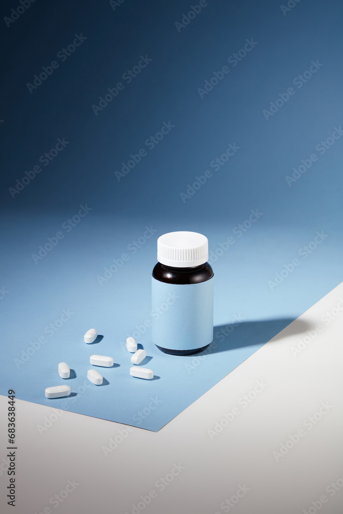 The white tablets are displayed with an unlabeled medicine bottle ...