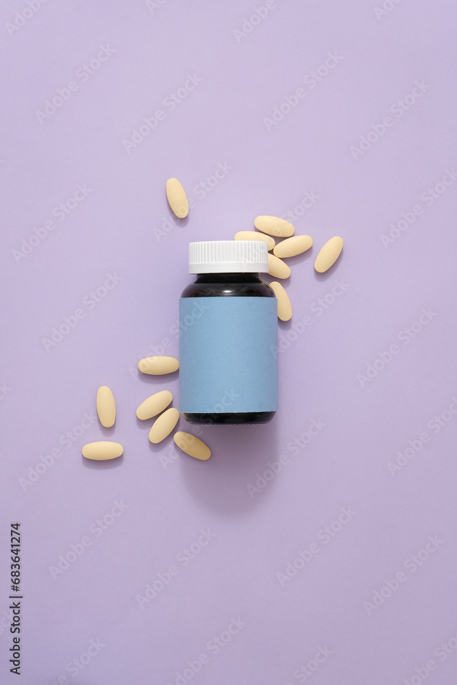 Beige tablets and an unlabeled medicine bottle are displayed against a ...