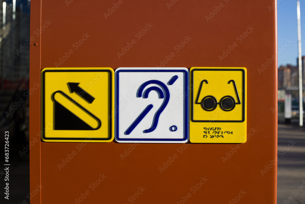 Three signs on the wall in front of the entrance directing blind and ...