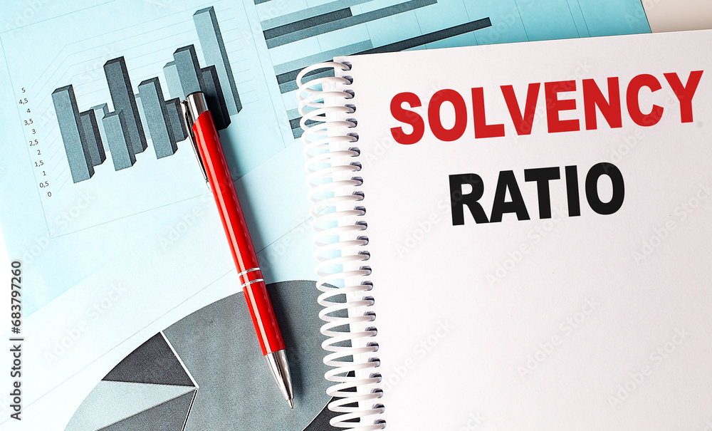 SOLVENCY RATIO text on a notebook with pen on a chart background Stock ...