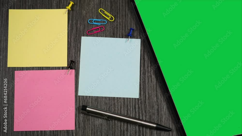 Top view office table with sticky notes and green tablet screen. Blank ...