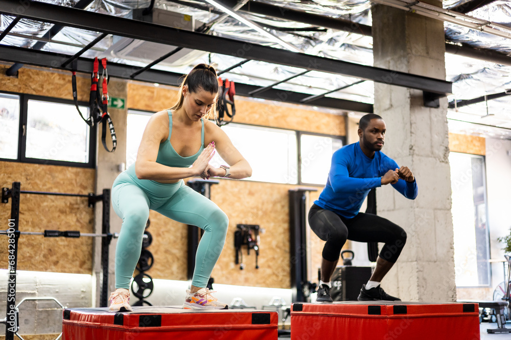 A couple of young people of different ethnicities are jumping on a ...