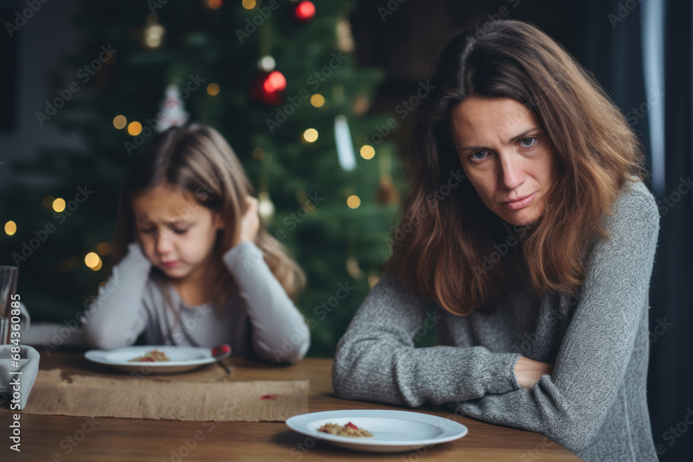Sad Christmas at home. Upset mother and her little girl sitting at ...