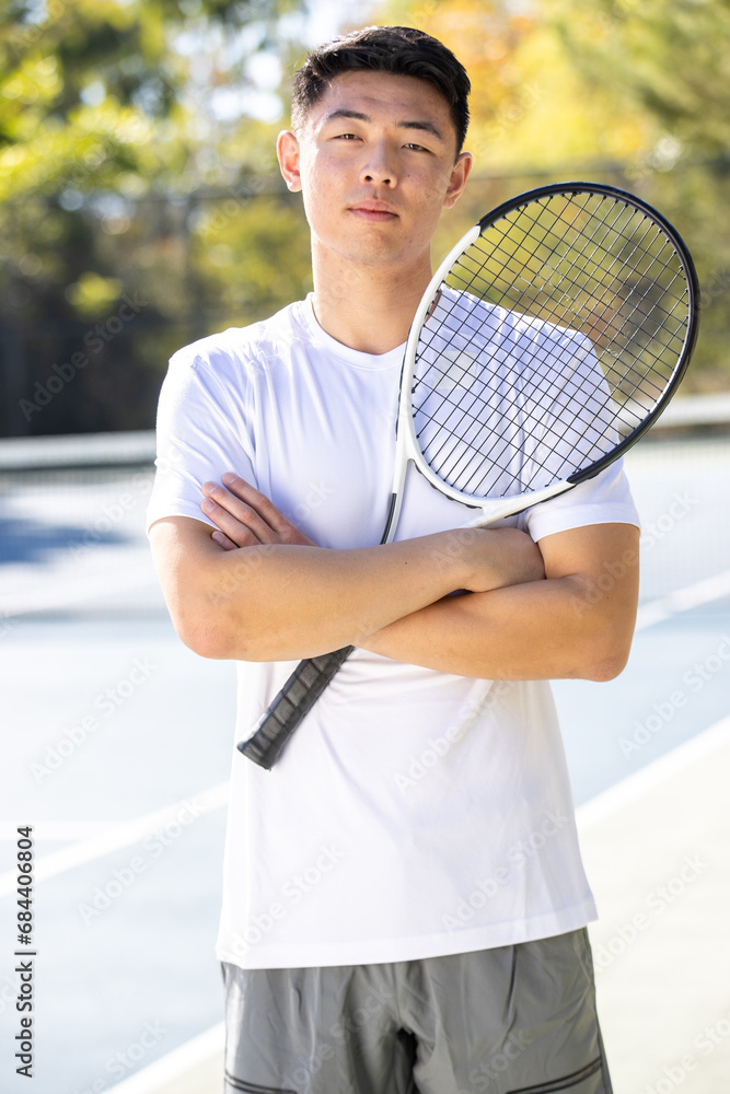 Confident Asian man holding a tennis racket. The player is ready for a ...