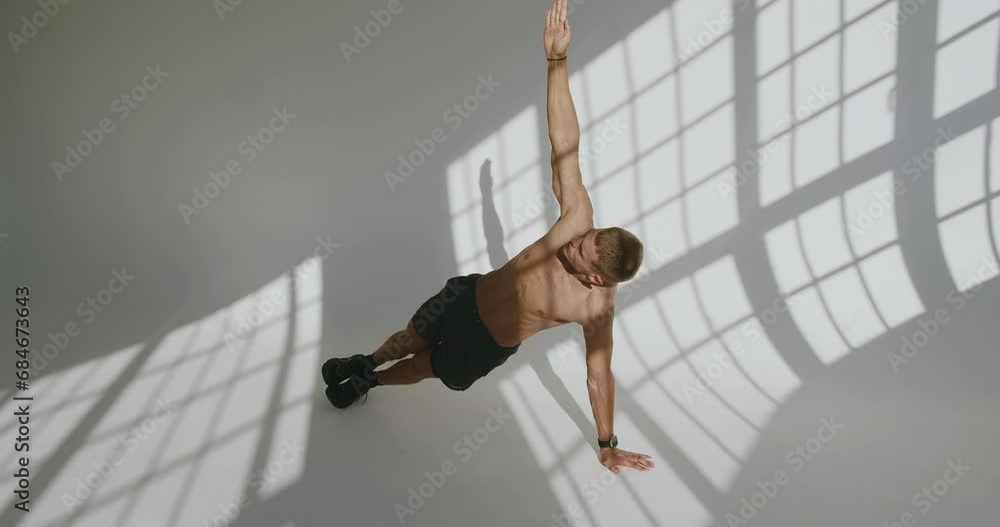 Shirtless man with muscular body has workout and doing side plank ...