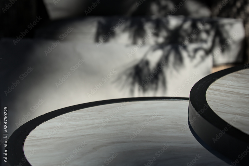 nested marble tables with black border and pine needle branch shadow ...