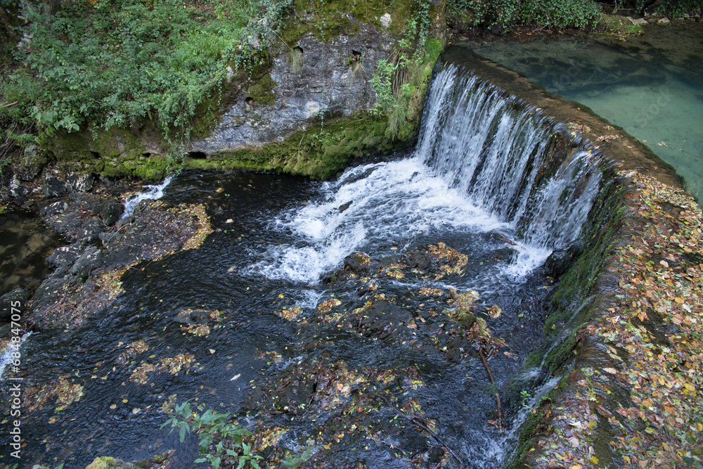 A small waterfall created by a concrete dam at the source of Krupajsko ...